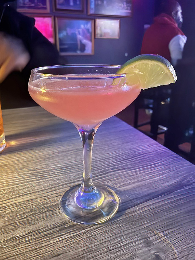 The pink cocktail that says, "Yes, you can be sophisticated while eating barbecue." That lime wedge isn't just garnish—it's setting boundaries.