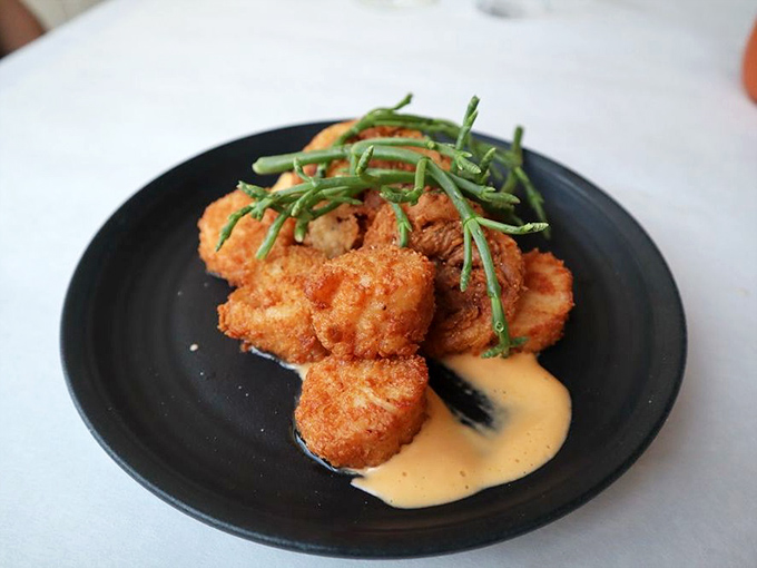 Crispy scallops lounging in a pool of velvety sauce – the seafood equivalent of putting on sweatpants after wearing a tuxedo all day.