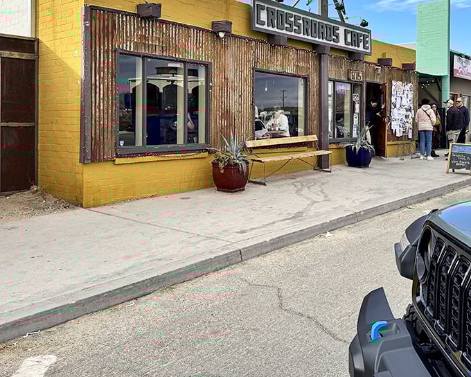 Crossroads Café's bright yellow exterior promises comfort food with desert flair. The rustic corrugated metal adds that perfect touch of authenticity.