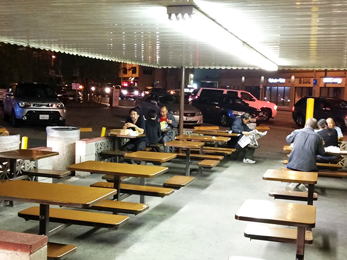 The outdoor dining area – where strangers become friends united by the universal language of "I can't believe I ate the whole thing."