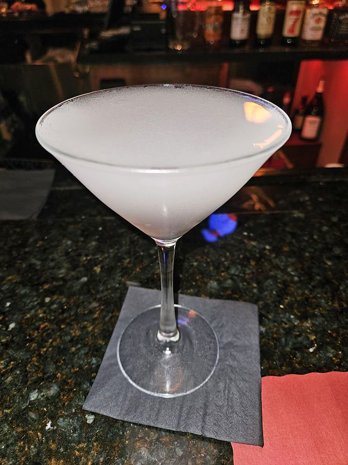 A perfectly chilled martini awaits its destiny at the bar – the liquid equivalent of a crisp white shirt in a world of graphic tees.