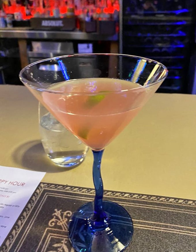 Cocktail craftsmanship in a blue-stemmed glass. This isn't just a drink—it's liquid architecture with flavor foundations built to impress.