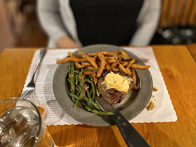 Filet mignon with a pat of butter slowly melting into beefy perfection, paired with green beans and fries that aren't just sides—they're supporting actors deserving their own award.