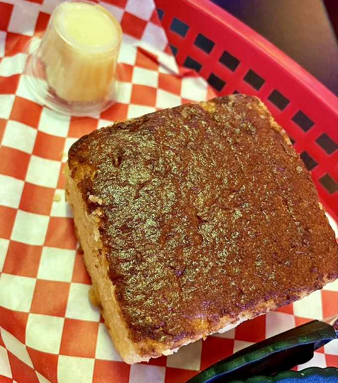 Golden cornbread with honey butter waiting nearby—the unsung hero of BBQ that deserves its own spotlight and fan club.