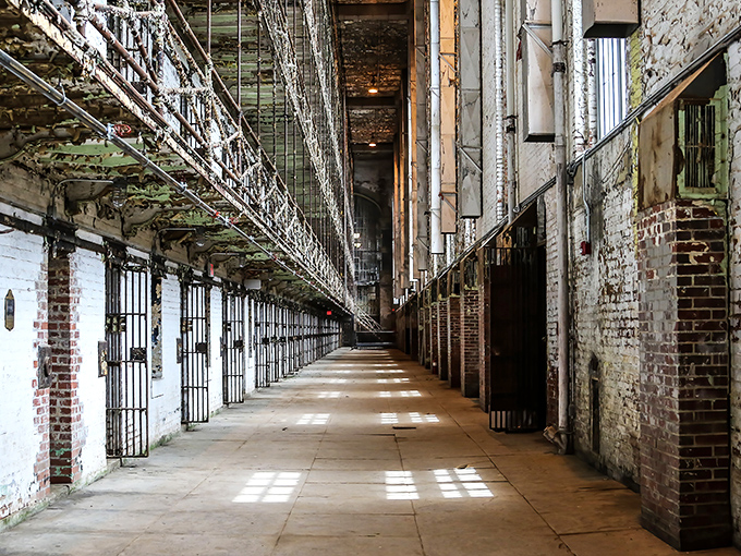Cell block hallway stretching toward infinity. The perspective makes you feel small – exactly the point in a place designed to humble its residents.