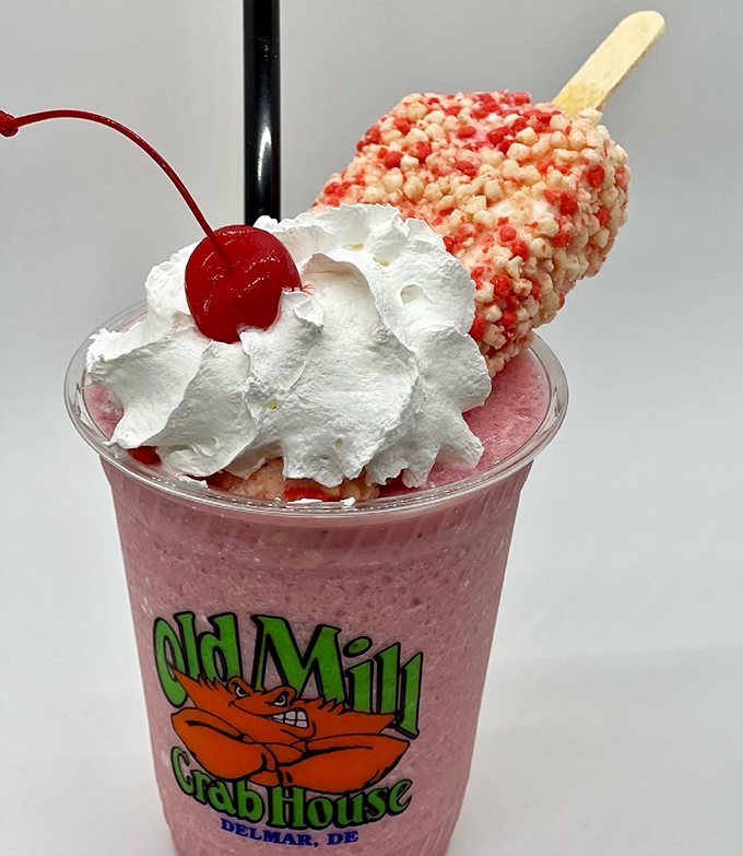 A strawberry shake topped with whipped cream and a popsicle—because sometimes dessert should look like it's dressed for its own party.