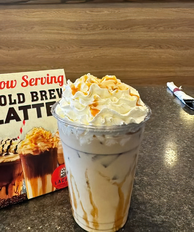 This isn't just iced coffee—it's a towering monument to caffeine topped with a cloud of whipped cream that deserves its own zip code.