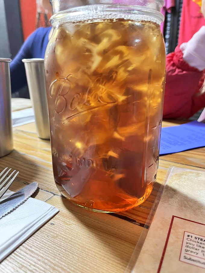 Sweet tea served in a Mason jar—because in the South, proper hydration comes with enough sugar to make your dentist wince.