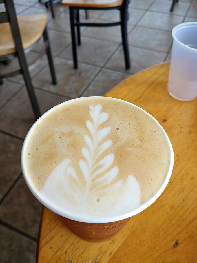 Latte art that doesn't need an Instagram filter—a simple leaf pattern that says, "We care about your coffee, but we're not going to lecture you about single-origin beans."