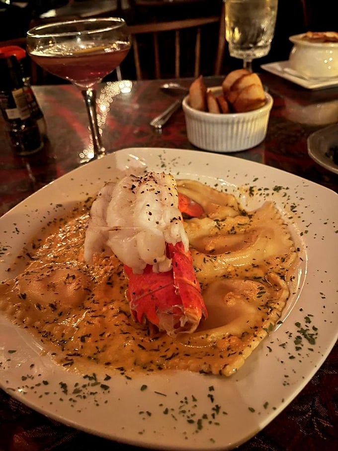 Lobster ravioli swimming in a sea of herb-flecked butter sauce. The lobster claw is basically waving "come and get me!"