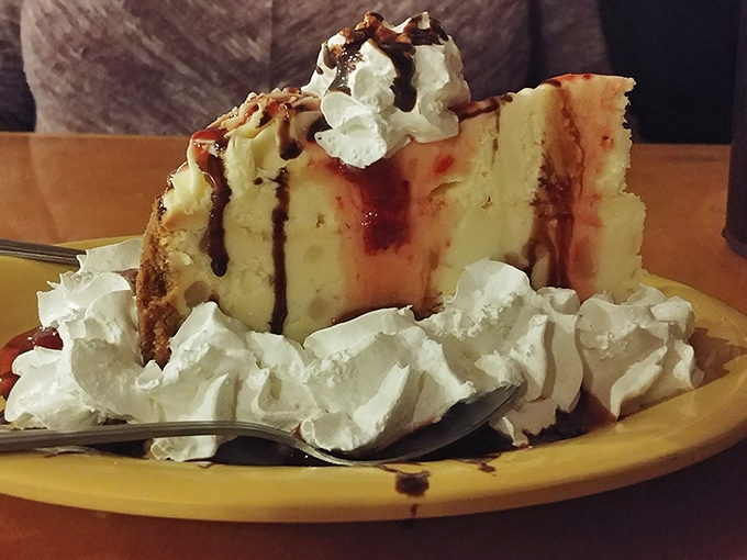 This cheesecake doesn't just end a meal—it creates a memory. Whipped cream, chocolate drizzle, and a slice generous enough to share (but you won't want to).