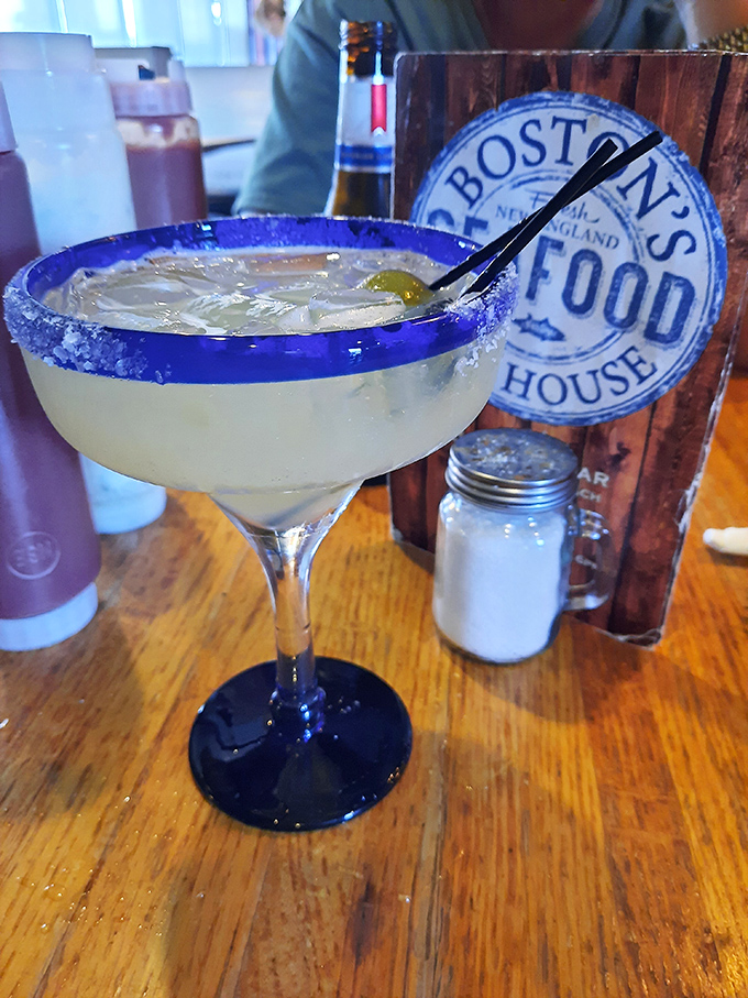 A salt-rimmed margarita beside the restaurant's logo—because nothing complements seafood quite like the bright, citrusy kick of a well-crafted cocktail.
