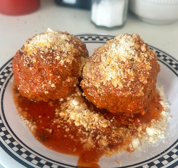 These meatballs aren't just swimming in tomato sauce, they're taking a luxurious spa bath in it – crowned with a snowfall of parmesan.