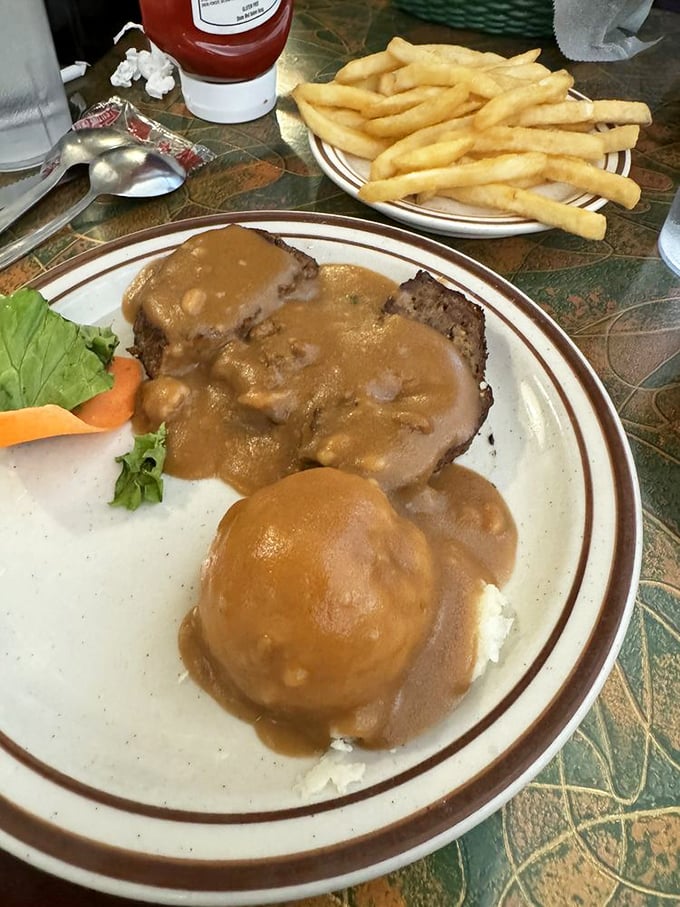Meatloaf and mashed potatoes swimming in gravy—the kind of plate that makes you want to call your mother and apologize.