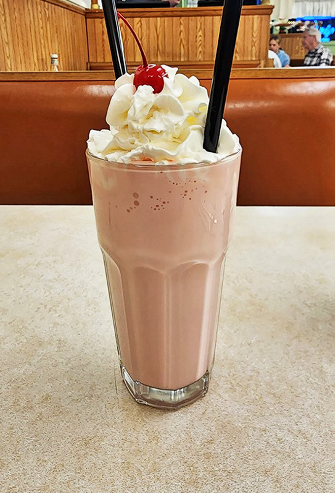 This isn't just a strawberry shake—it's a frothy pink promise of happiness topped with whipped cream and childhood memories.
