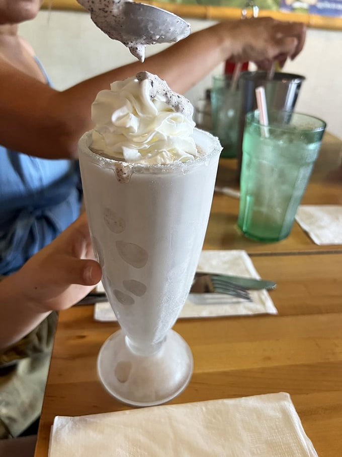 This isn't just a milkshake – it's a tower of creamy nostalgia topped with enough whipped cream to make your inner child high-five your adult self.