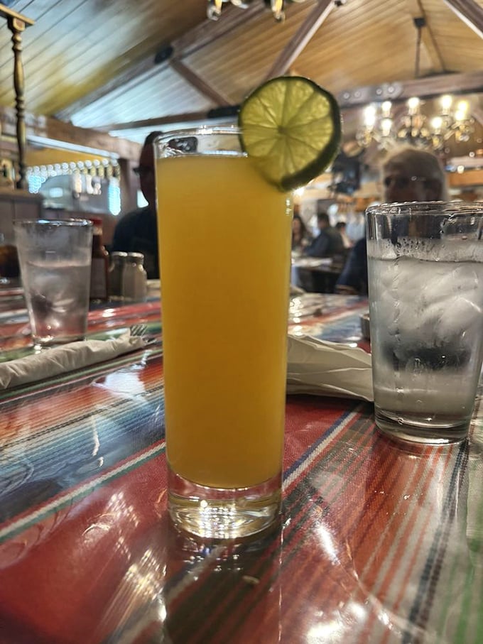 A sunshine-yellow cocktail garnished with lime – liquid California in a glass, perfect for toasting good company in wood-paneled splendor.
