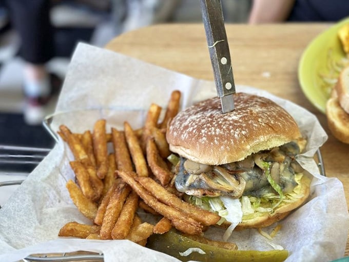 Burger perfection isn't complicated—it's this mushroom-topped masterpiece with hand-cut fries that would make your cardiologist wince and your taste buds applaud.