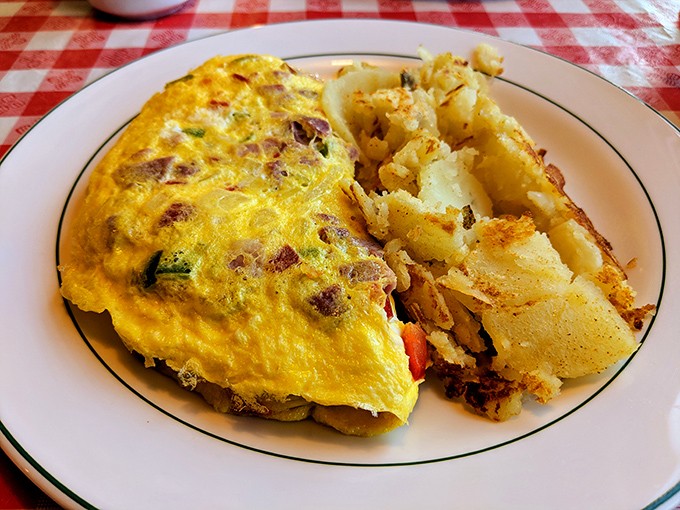 Sunshine on a plate – this omelet practically glows with eggy perfection, while home fries stand by as the faithful, crispy-edged sidekick.