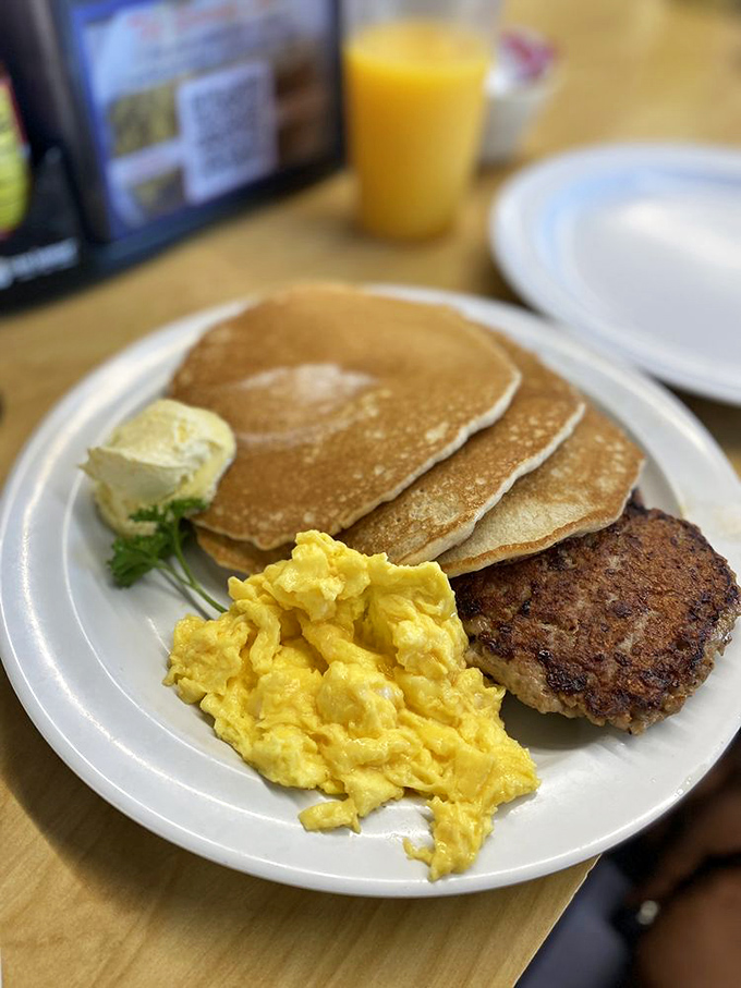 Golden pancakes with a pat of butter slowly melting into their fluffy depths. Scrambled eggs and sausage complete this breakfast trifecta.