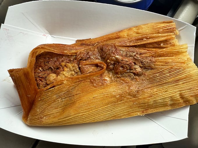 Unwrap this pork tamale like the present it is—tender meat swimming in rich red sauce, all cradled in perfectly steamed masa. This isn't food; it's an experience.