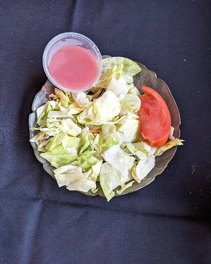 Even the house salad knows its role—a brief, refreshing intermission before the main event takes center stage.