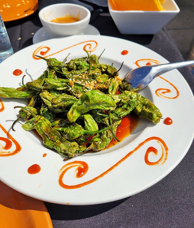 Blistered shishito peppers that play culinary roulette—most are mild, but occasionally one brings the heat that makes the game exciting.