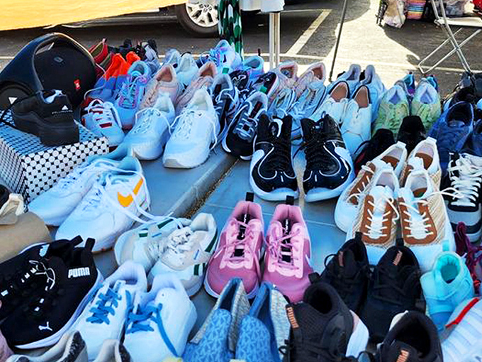 Sneakerhead heaven spread across blue tarps. Each pair tells a story and promises adventures yet to come, no software updates required.