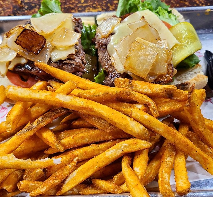A steak sandwich that doesn't hide behind fancy names or pretentious toppings—just honest beef with caramelized onions and golden fries.