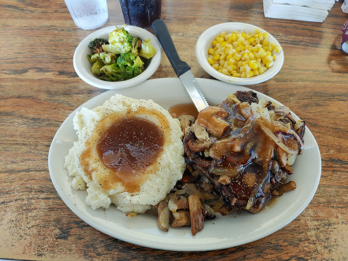 Salisbury steak swimming in rich gravy alongside creamy mashed potatoes. This plate doesn't just feed you—it hugs you from the inside.