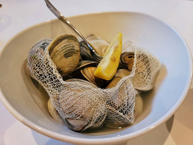 Steamed clams nestled in their broth like tiny treasures waiting to be discovered. That lemon wedge isn't just garnish—it's essential equipment.