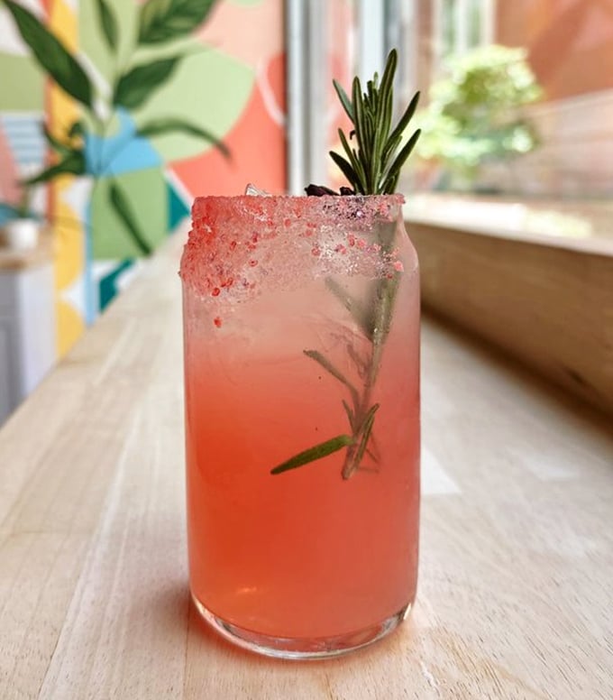 A pink drink that's part cocktail, part magic potion. That sprig of rosemary isn't just garnish – it's an aromatic invitation to slow down.