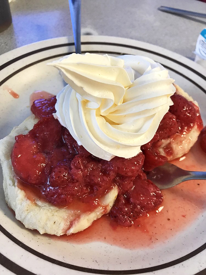 The strawberry biscuit—where fruit and pastry unite in a sweet-tart symphony topped with a cloud of whipped cream. Dessert disguised as breakfast.