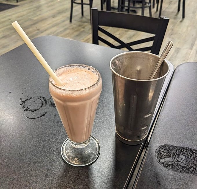 A classic strawberry milkshake in its natural habitat – thick enough for a spoon, served in the traditional metal mixing cup for seconds.