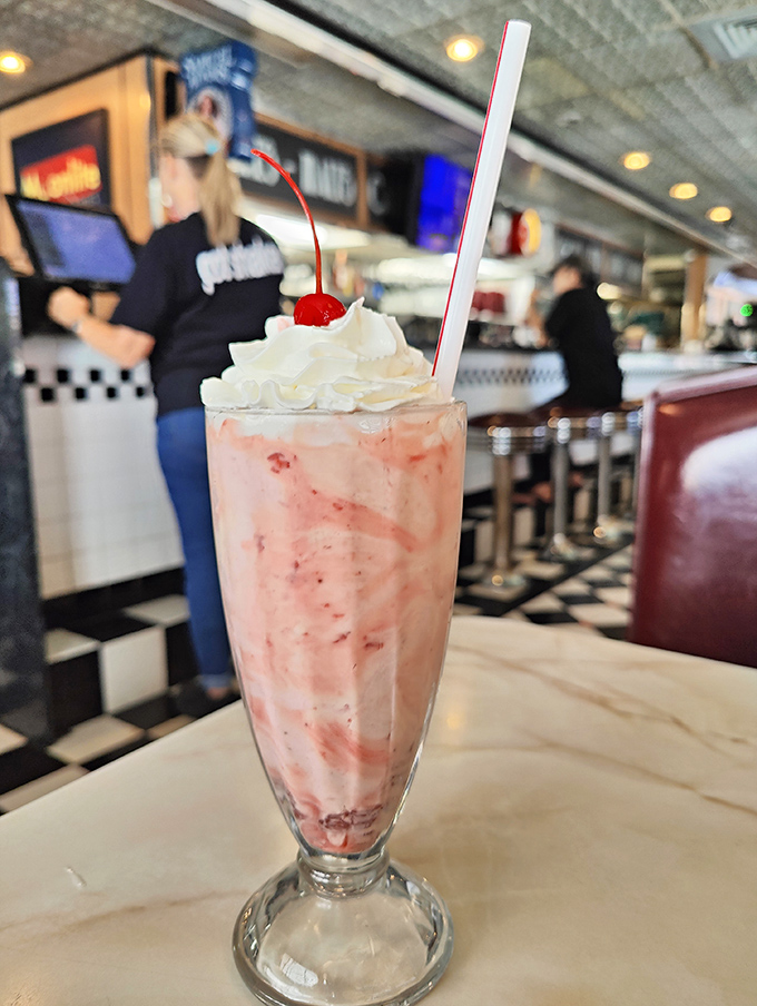 The strawberry milkshake arrives like a pink cloud topped with whipped cream and a cherry—Instagram was invented for moments like this.