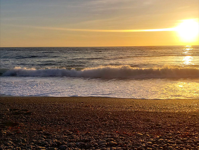 Golden hour transforms the obsidian shore into a glittering wonderland—Mother Nature's ultimate light show.