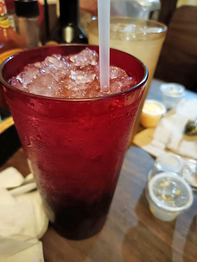 That sweet tea isn't just a beverage—it's liquid Southern hospitality served in a ruby-red glass that sweats almost as much as you will in a Dallas summer.