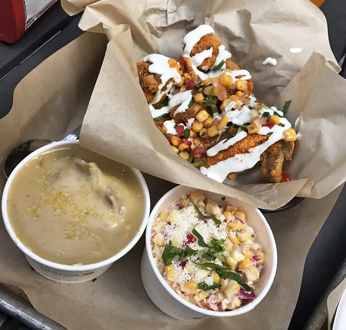 A feast for both eyes and stomach—crispy chicken, creamy sides, and what appears to be a corn salad creating the holy trinity of comfort food.