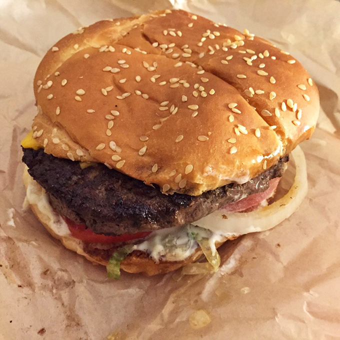 This isn't just any burger – it's a Texas-sized flavor bomb with all the fixings that demands a two-handed commitment.