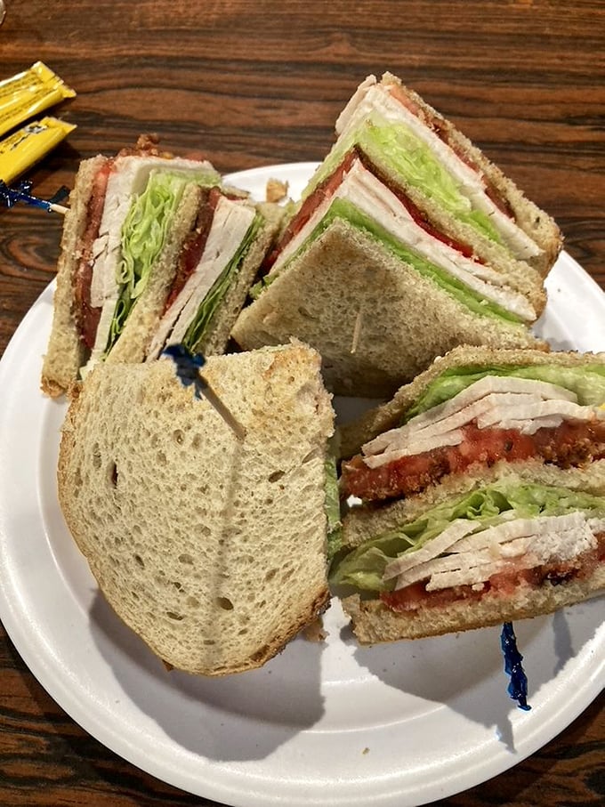 The turkey club—architectural marvel of the sandwich world. Layers of thinly sliced turkey, crisp vegetables, and toast create the skyscraper of lunch options.