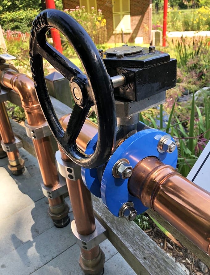 Industrial art meets garden function with this vintage valve wheel—a reminder that beneath Wellfield's beauty lies the practical purpose of water management. 