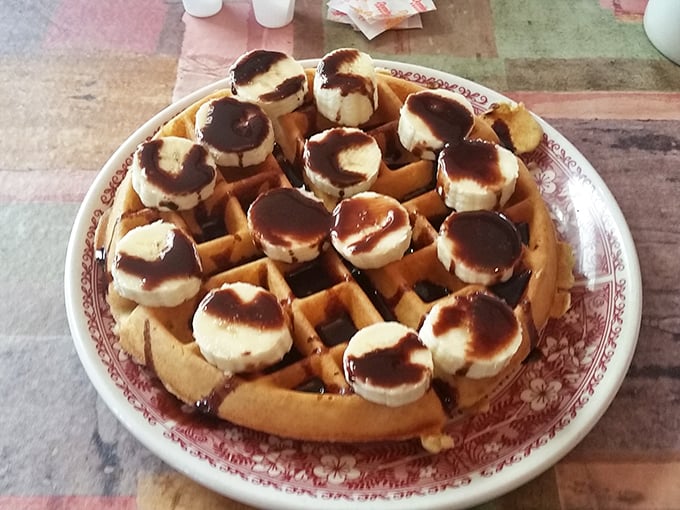 A waffle that's clearly living its best life, topped with bananas and chocolate that make breakfast feel like you're getting away with something.