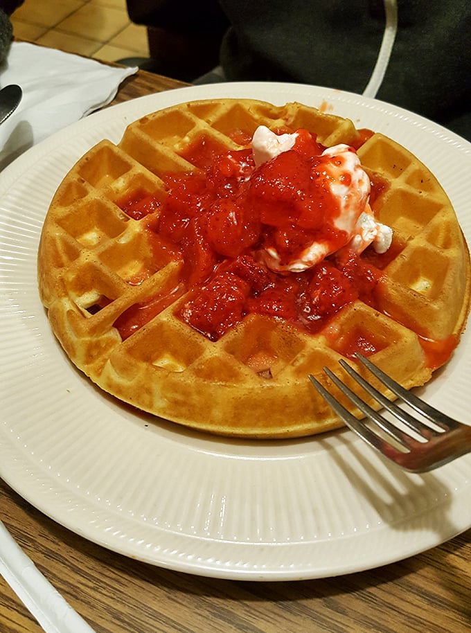That golden waffle doesn't just hold strawberries and cream—it cradles summer memories and childhood joy in every perfect square.