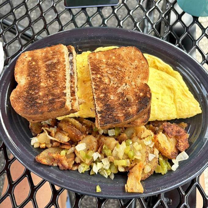 Breakfast sandwich architecture at its finest – perfectly grilled bread embracing fluffy eggs and savory fillings like old friends at a reunion.