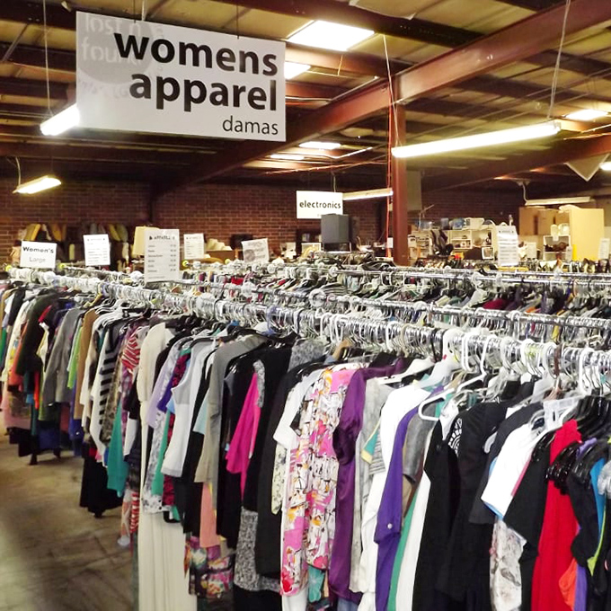 Women's apparel stretches as far as the eye can see—a fabric forest where vintage treasures and barely-worn bargains hang side by side.
