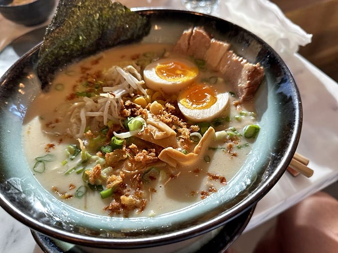 A ramen bowl that whispers sophistication while shouting flavor – those soft-boiled eggs are practically winking at you.