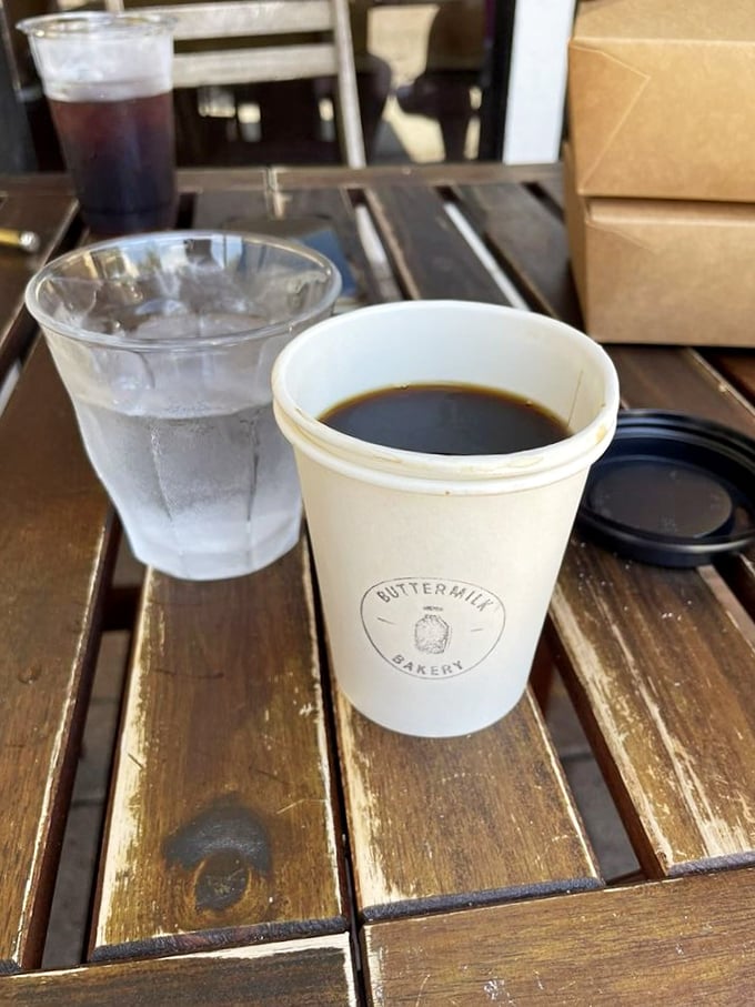 Coffee served in a cup bearing the bakery's logo—a simple pleasure that says, "Take a moment, slow down, this sip deserves your full attention."