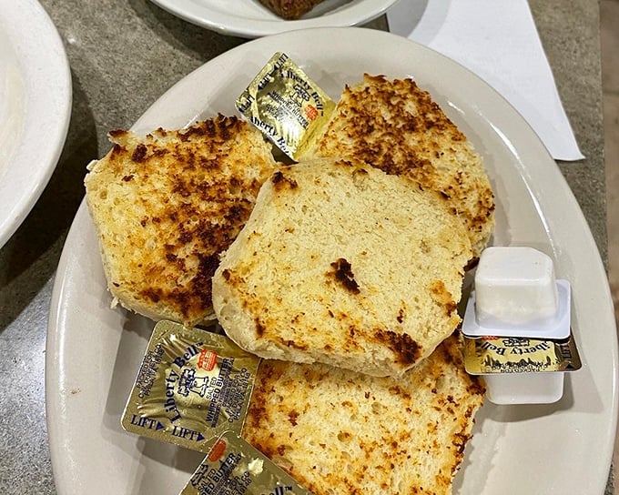Toast that's achieved celebrity status – golden-brown, perfectly crisped, and surrounded by butter packets like adoring fans seeking autographs.