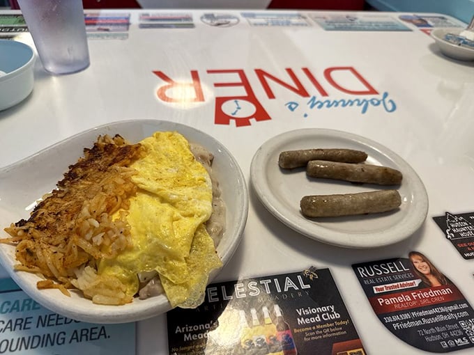 Breakfast hash browns crisped to golden perfection alongside eggs and sausage—the holy trinity of morning meals that makes waking up worthwhile.