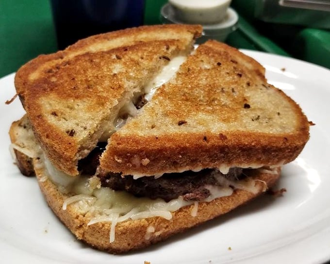 This patty melt isn't just grilled – it's been transformed into a buttery, cheesy masterpiece that would make your cardiologist wince and your taste buds sing.